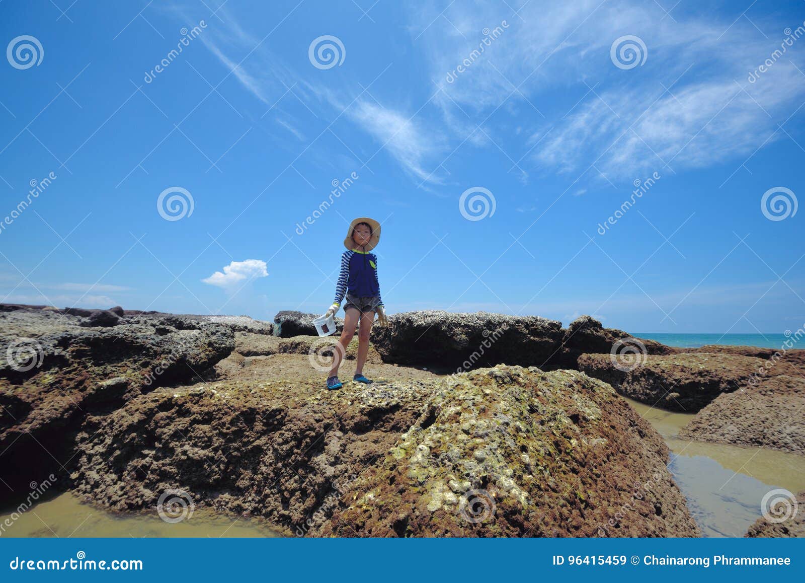 A Boy Plays Exploring at the Beach Rocks. Stock Image - Image of ...