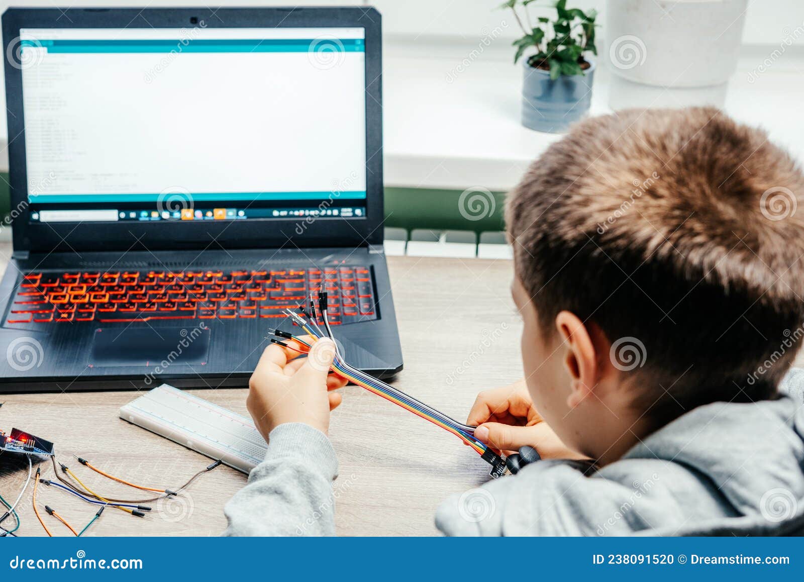 A Boy Plugging Cables To Sensor Chips while Learning Arduino Coding and Robotics Stock Photo ...