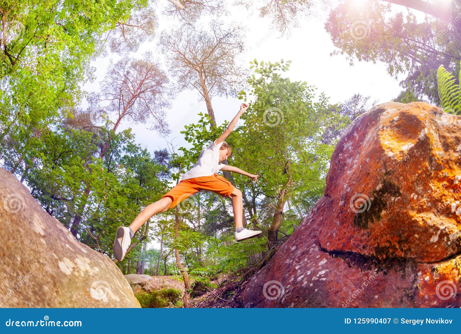 Boy in the Process of Jumping from Stone To Other Stock Image - Image ...