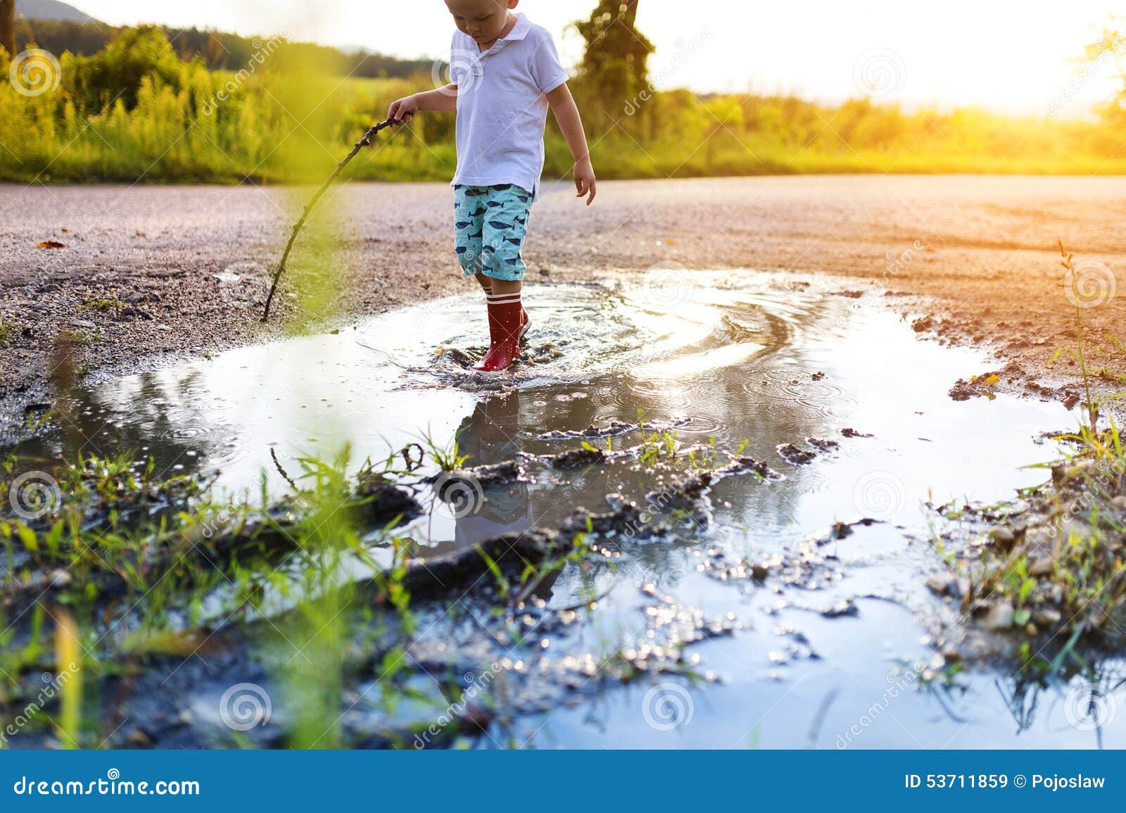 Boy in a puddle stock image. Image of shorts, walking - 53711859