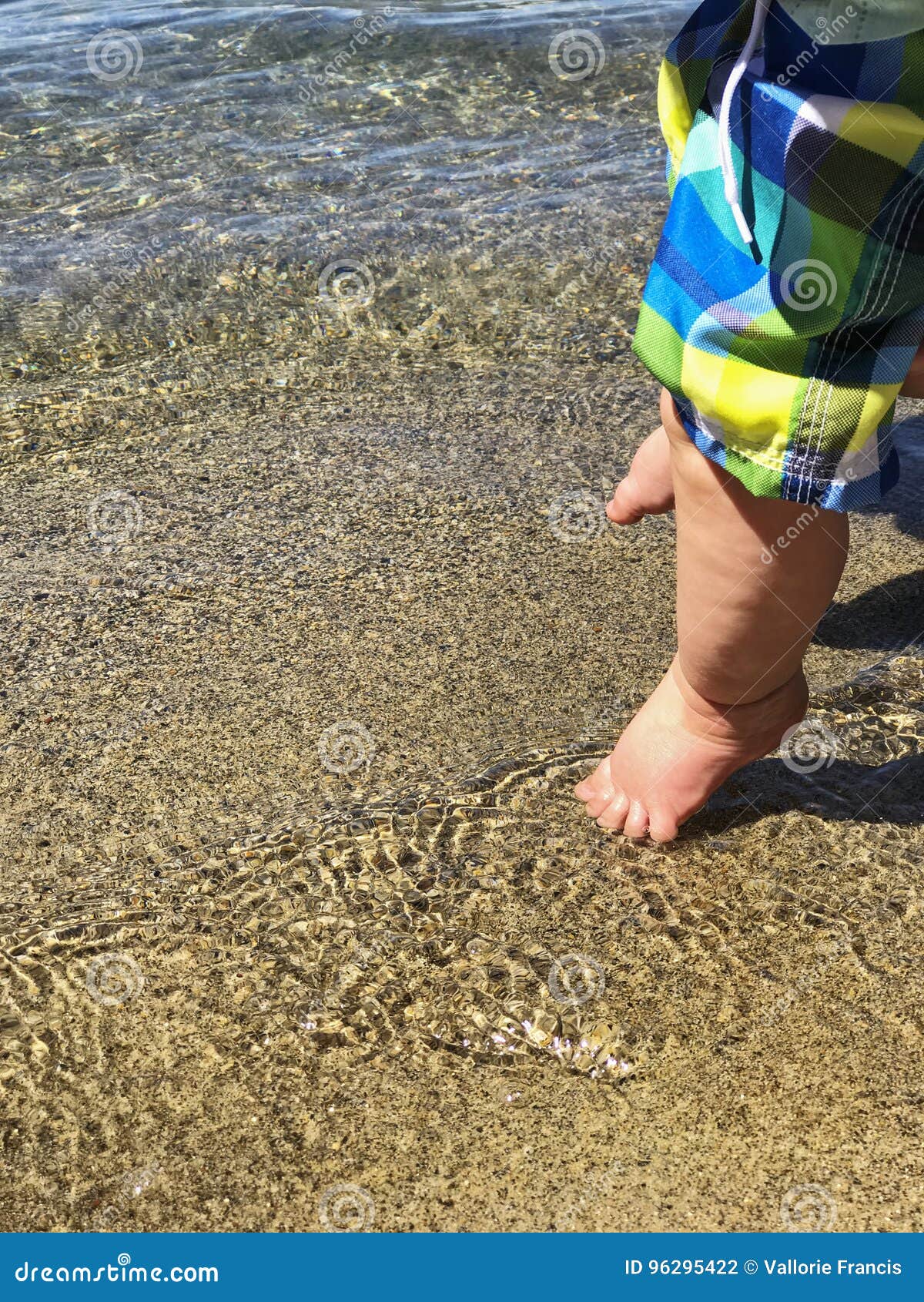 Boy putting toes in water stock photo. Image of child - 96295422