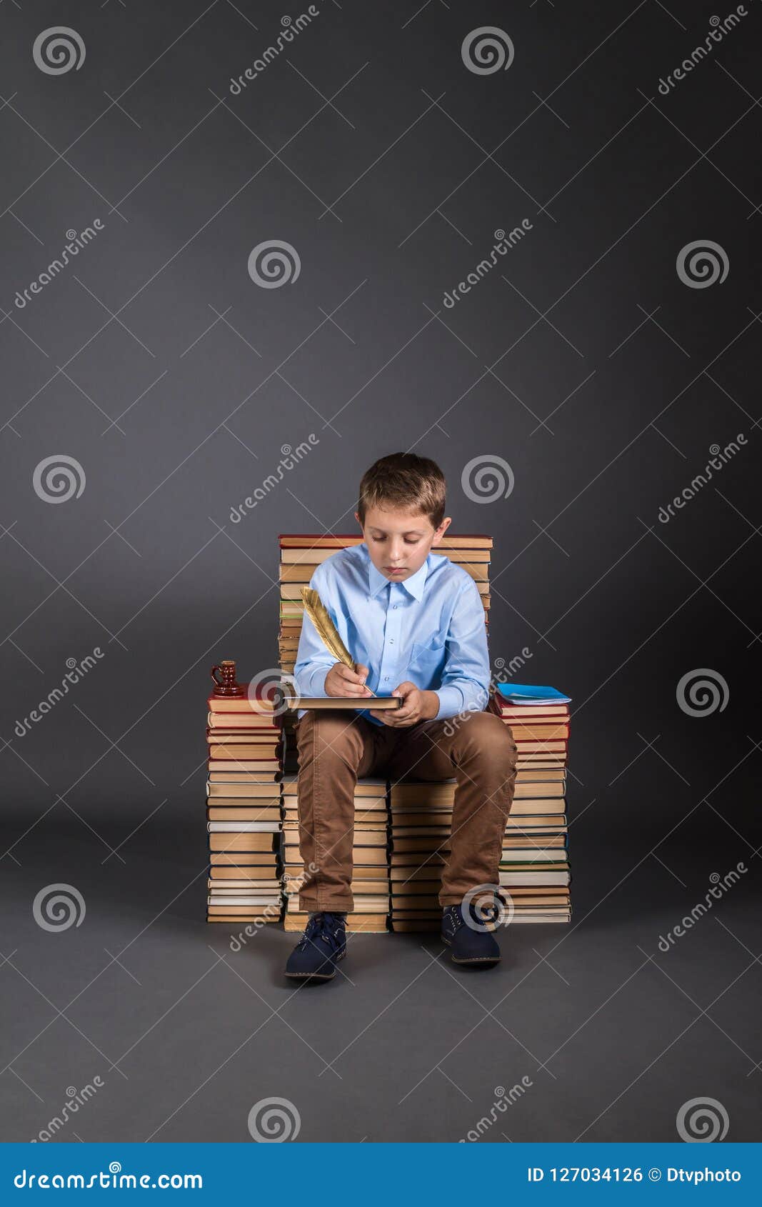 A Boy with Quill Pen Sits on a Throne of Books Stock Photo - Image of ...