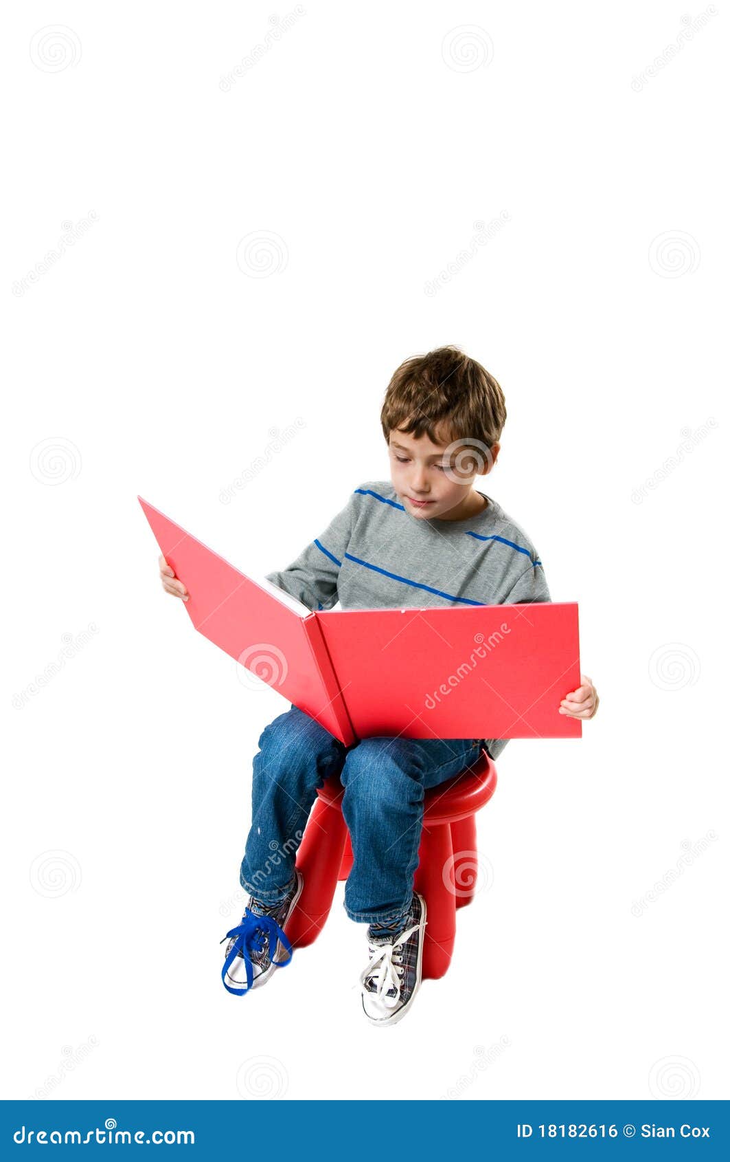 Boy reading a big red book stock photo. Image of person - 18182616
