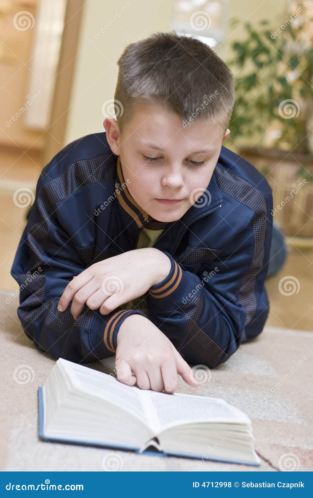 Boy reading book on carpet stock photo. Image of reading - 4712998