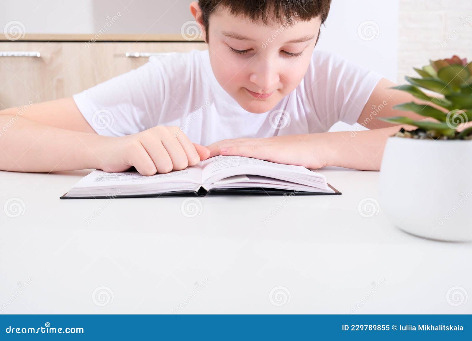 A Boy Reading a Book while Sitting by the Table Stock Image - Image of ...