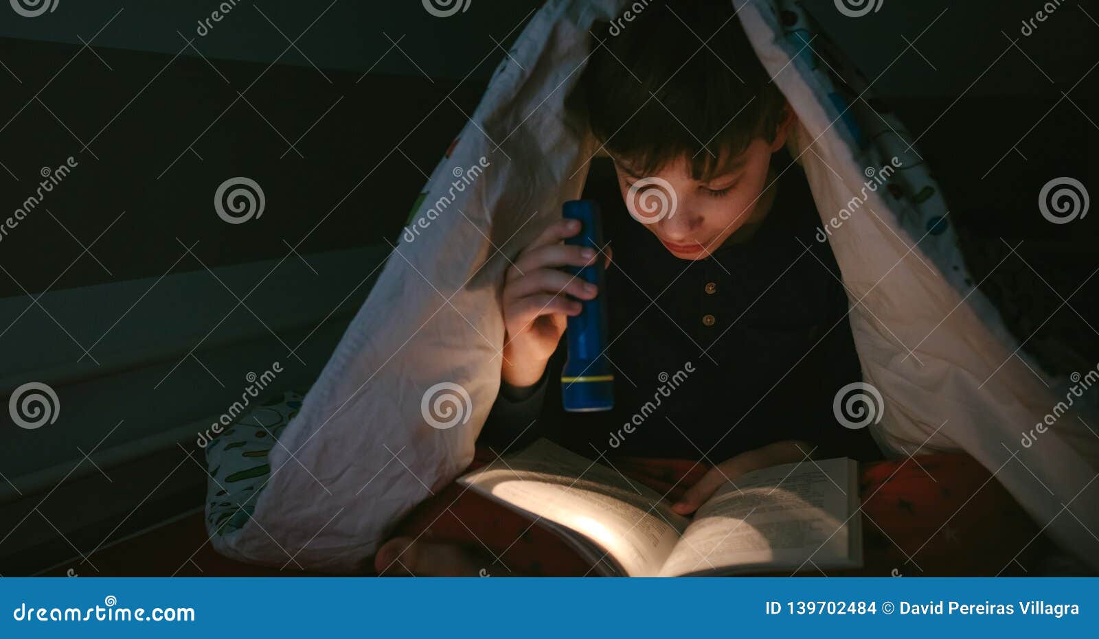 Boy Reading with a Flashlight Stock Photo - Image of lantern, covers ...