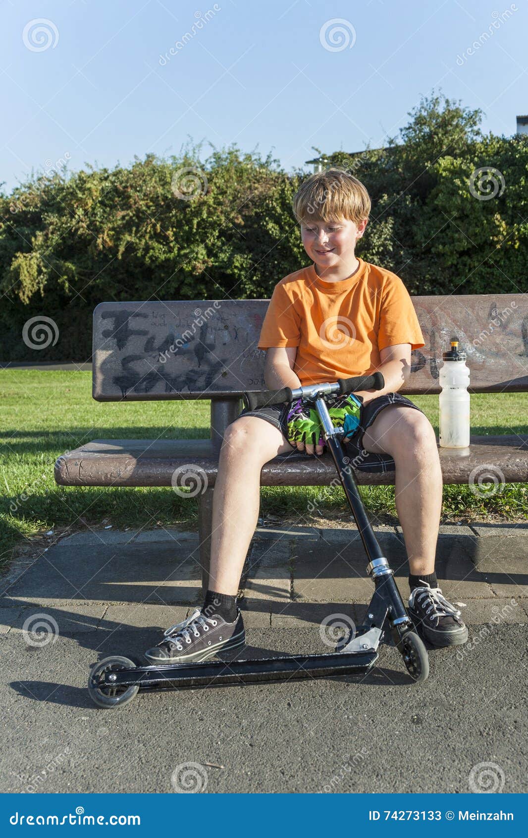 Boy Relaxes at a Bench from Riding Push Scooter Stock Image - Image of ...