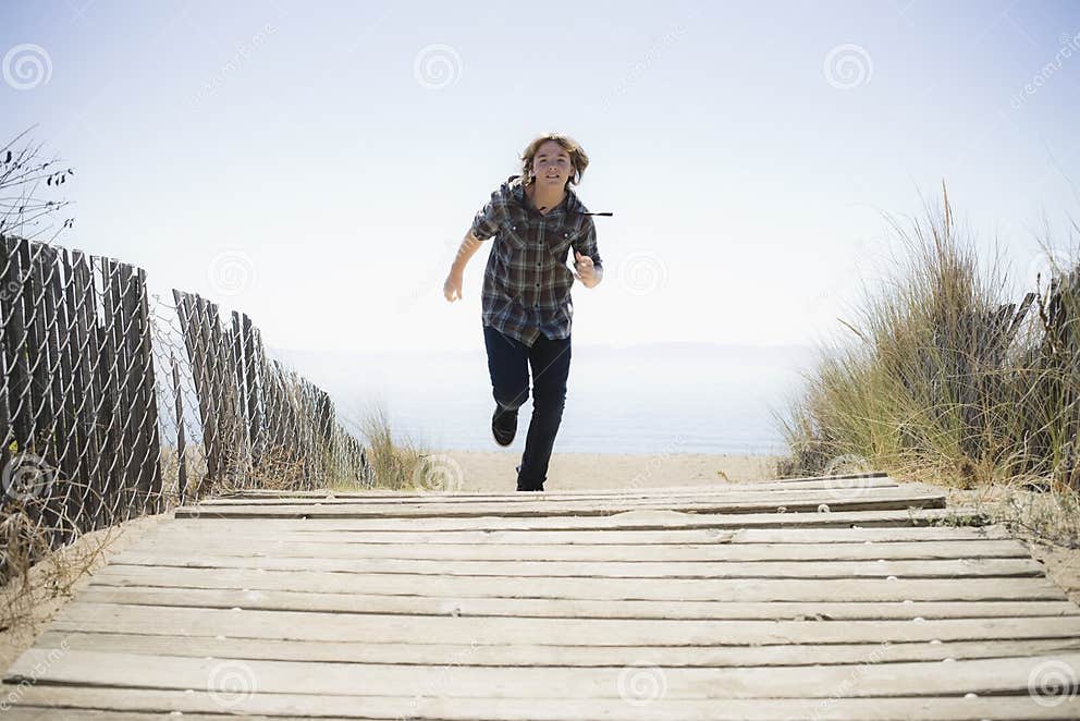 Boy Running on Beach Walkway Stock Photo - Image of tween, horizontal ...