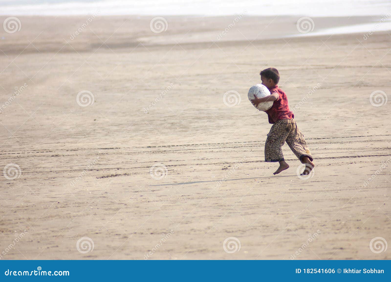A Boy Running Joyfully with a Ball on a Sandy Beach Editorial Photo ...