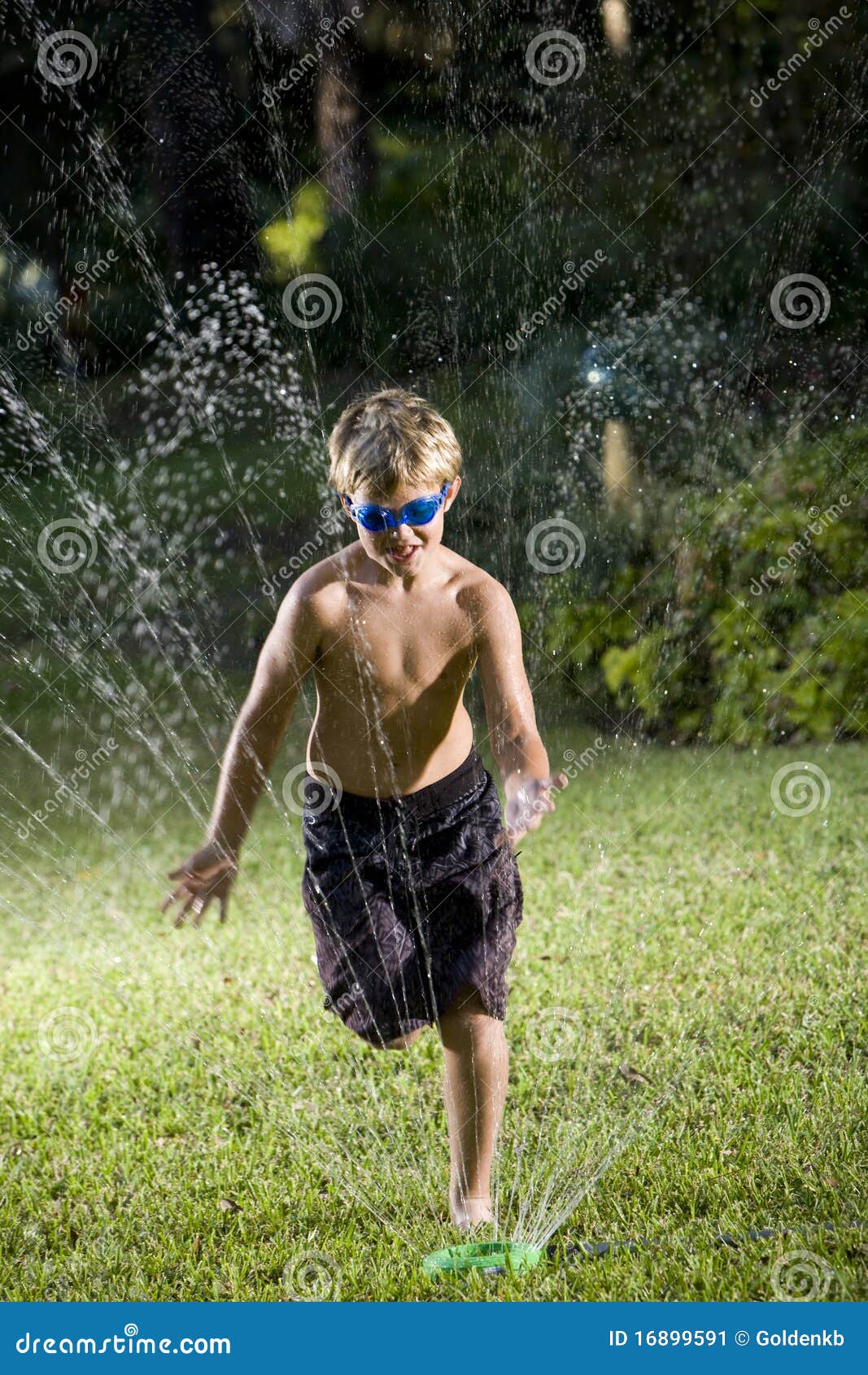 Boy Running through Lawn Sprinkler Stock Image - Image of child ...