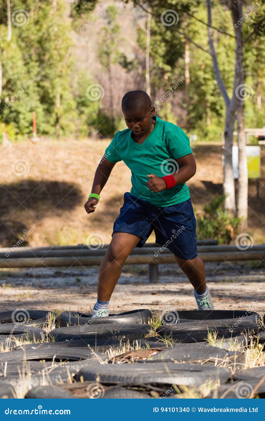 Boy Running Over Tyres during Obstacle Course Training Stock Photo ...