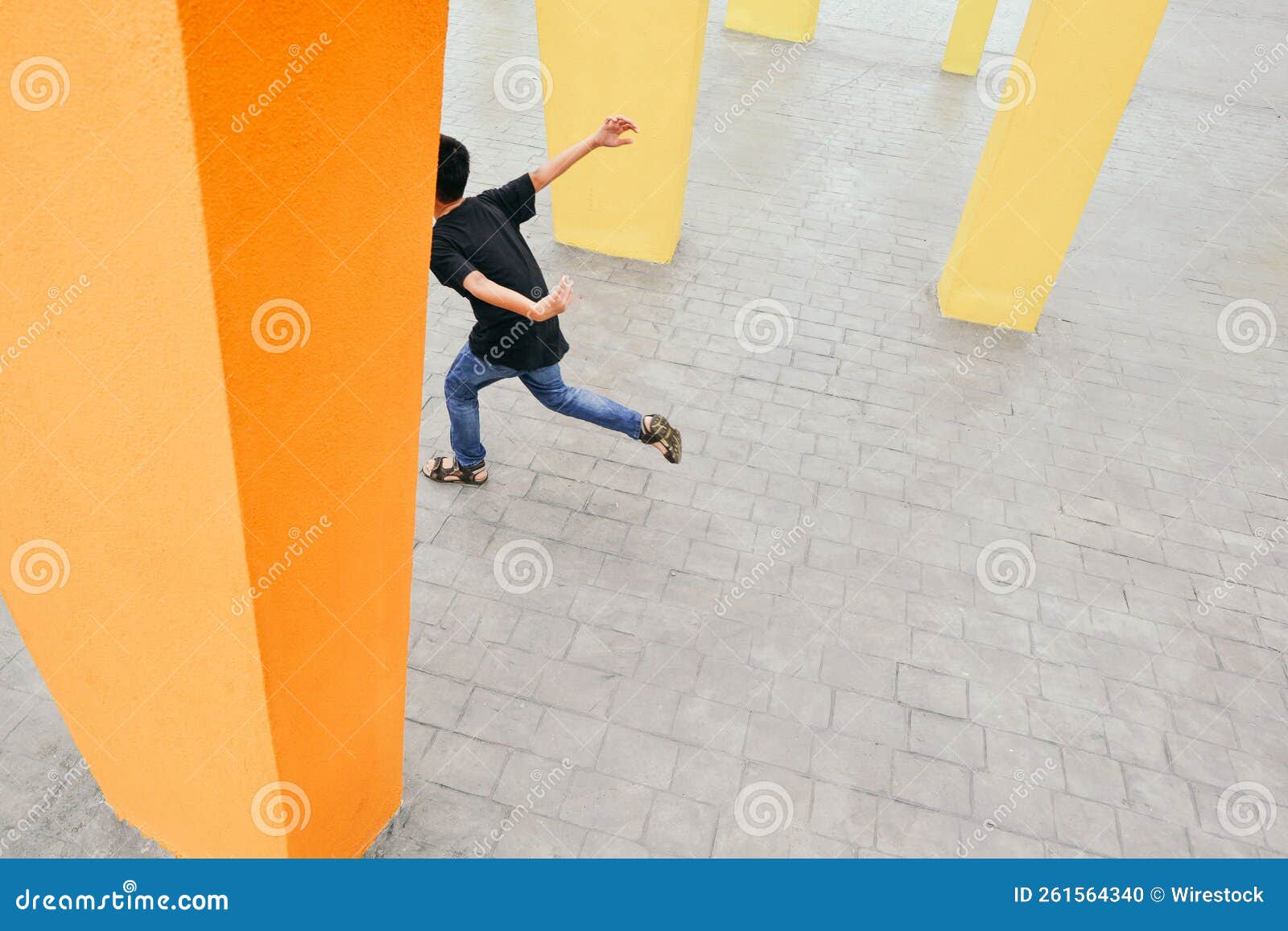 Boy Running between Yellow Columns Stock Photo - Image of leisure, wall ...
