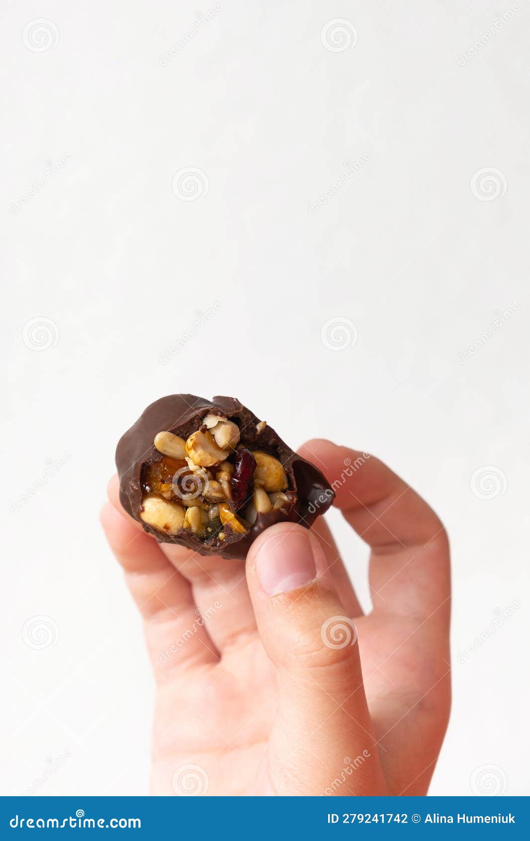 A Boy& X27;s Hand Holds a Bitten Craft Chocolate Candy with Nuts Stock ...