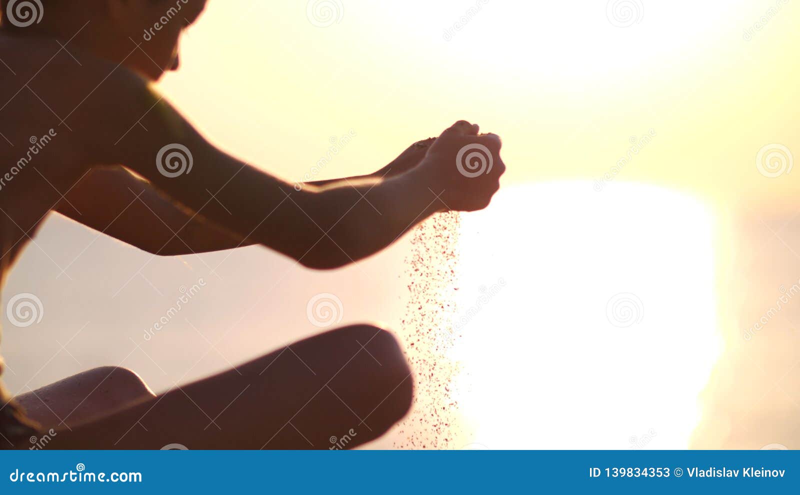Boy with Sand Falling through Her Hands on the Beach at Sunset Stock ...