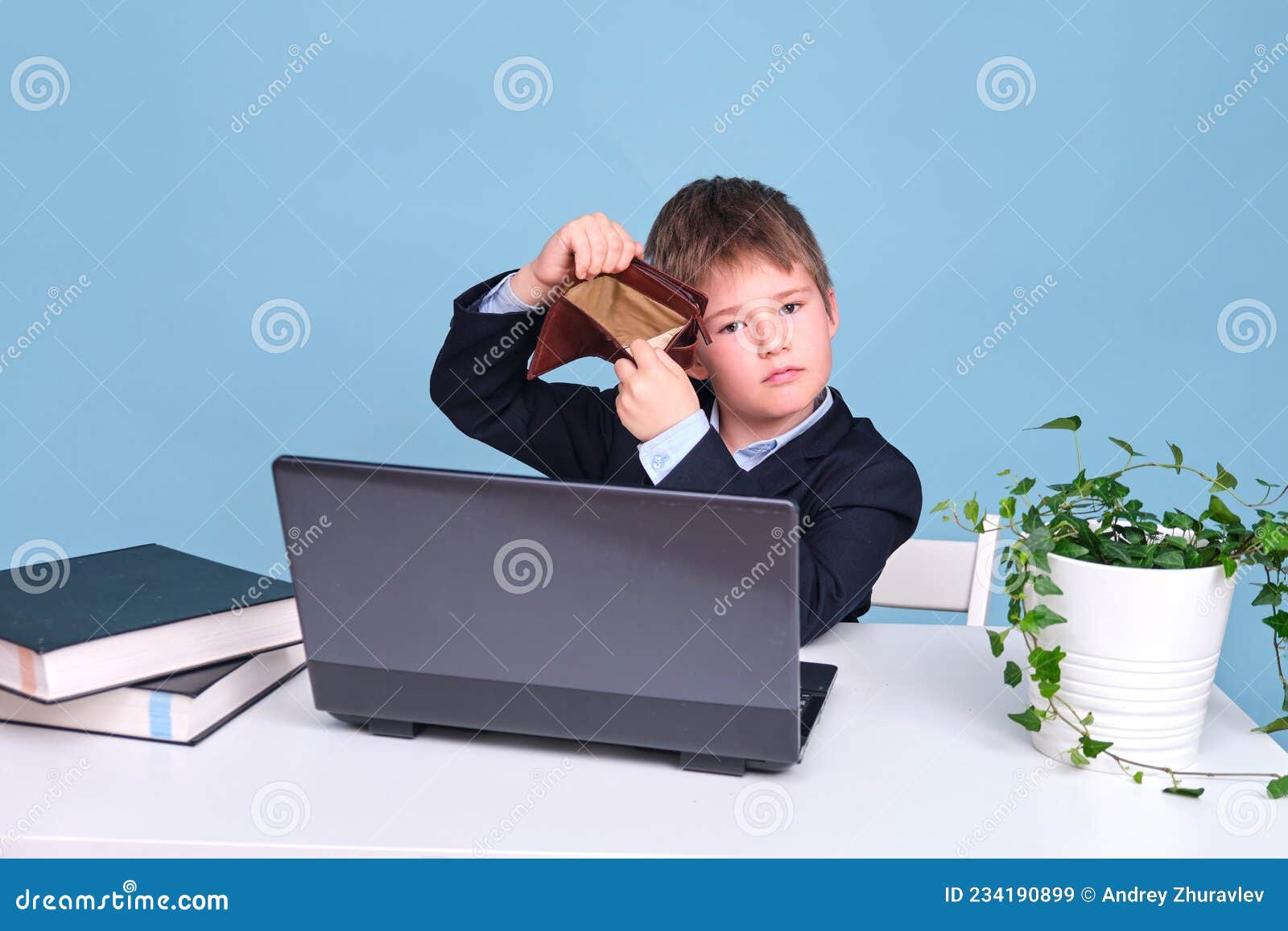 A Boy in a School Suit with an Empty Wallet, Copy Space on a Blue ...