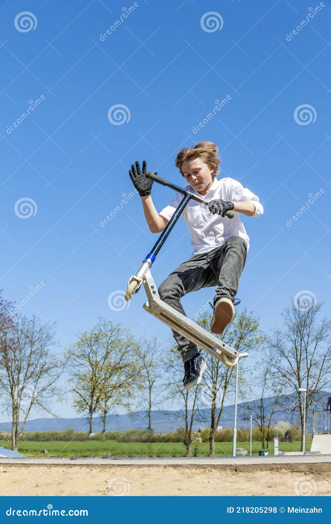 Boy with Scooter is Going Airborne at a Skate Park Under Blue Sky Stock ...