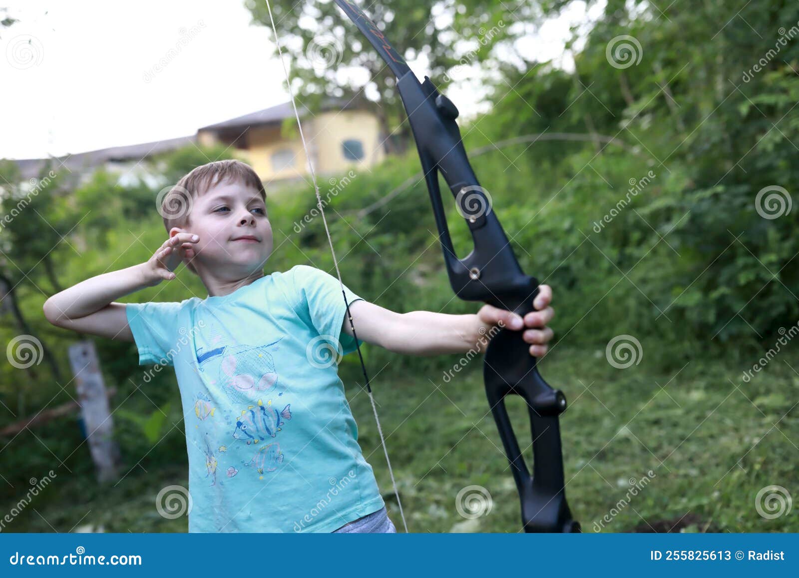 Boy shooting bow in park stock image. Image of concentration - 255825613