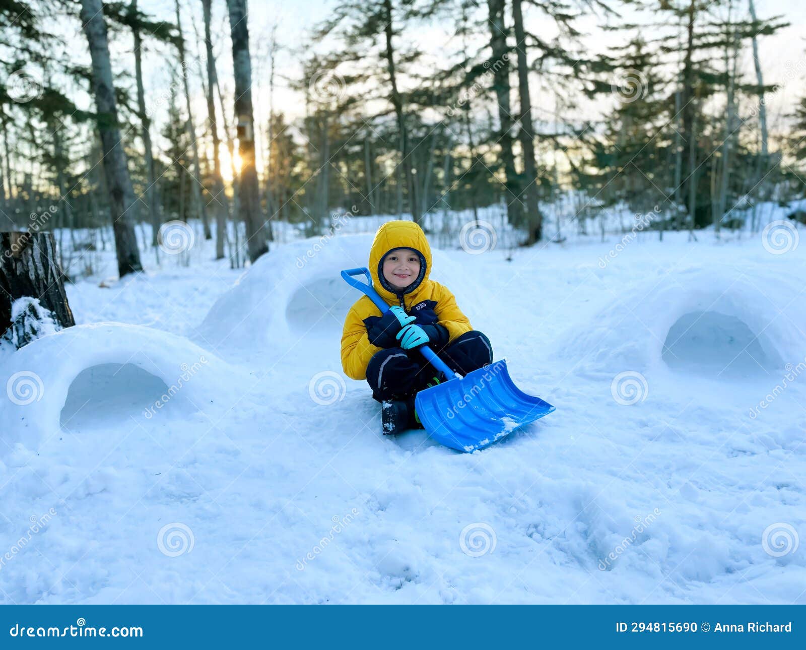 A Boy with a Shovel Built Igloos of Snow in the Backyard in Sunset ...