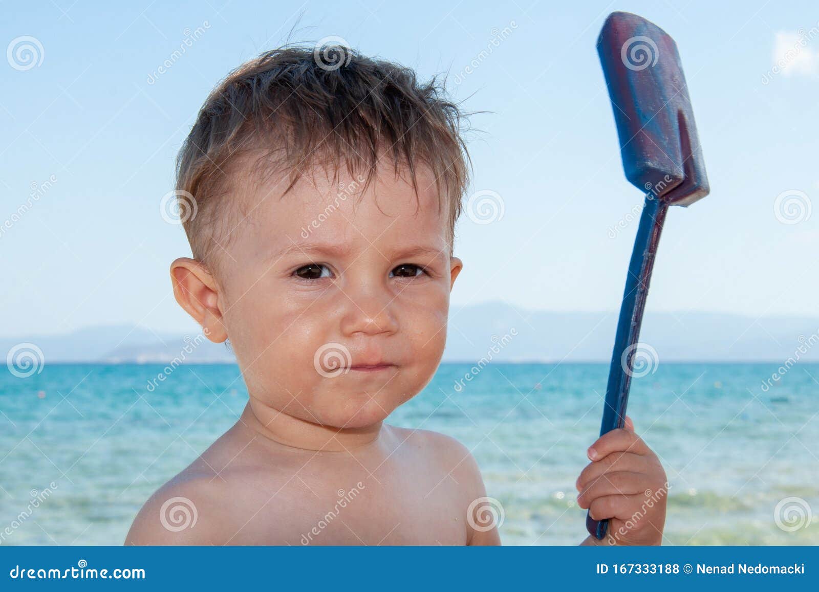 The Boy with a Shovel is Playing on the Beach. Stock Photo - Image of ...