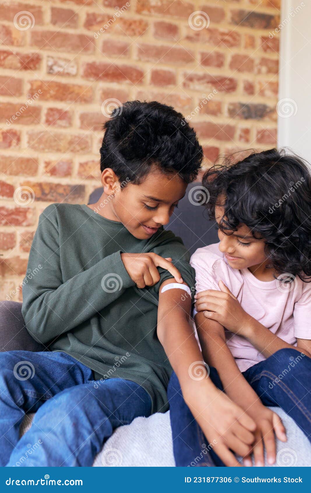 Boy Showing Younger Brother Plaster on Arm Stock Photo - Image of point ...