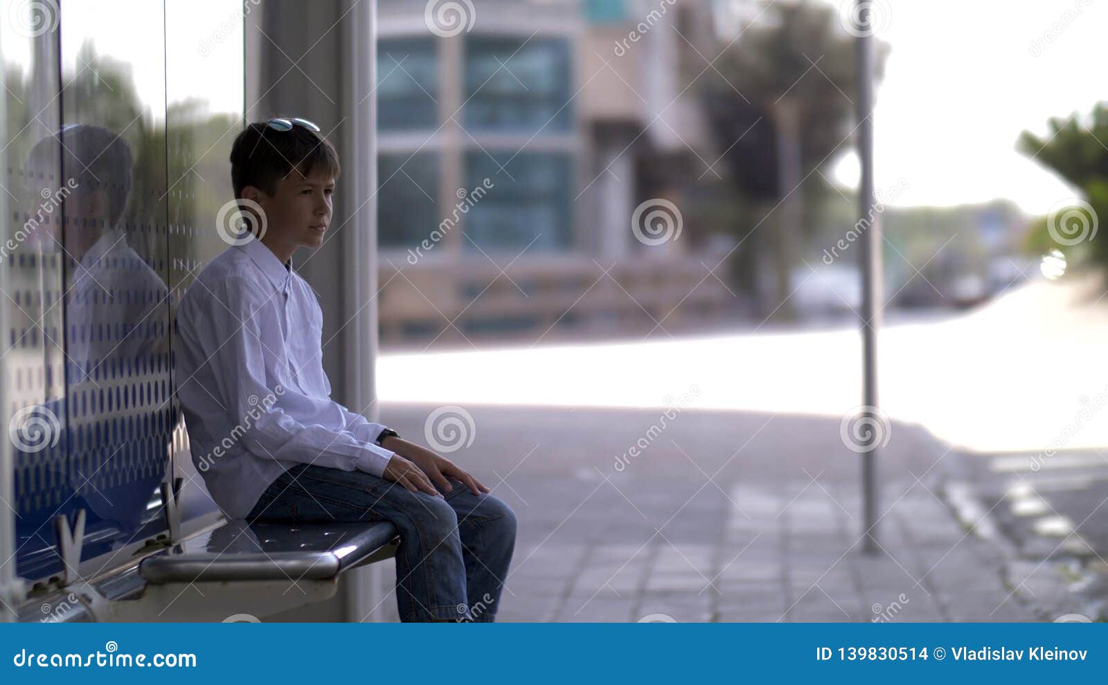 Boy Sits on the Bus Stop and Waits for the Bus Stock Photo - Image of ...
