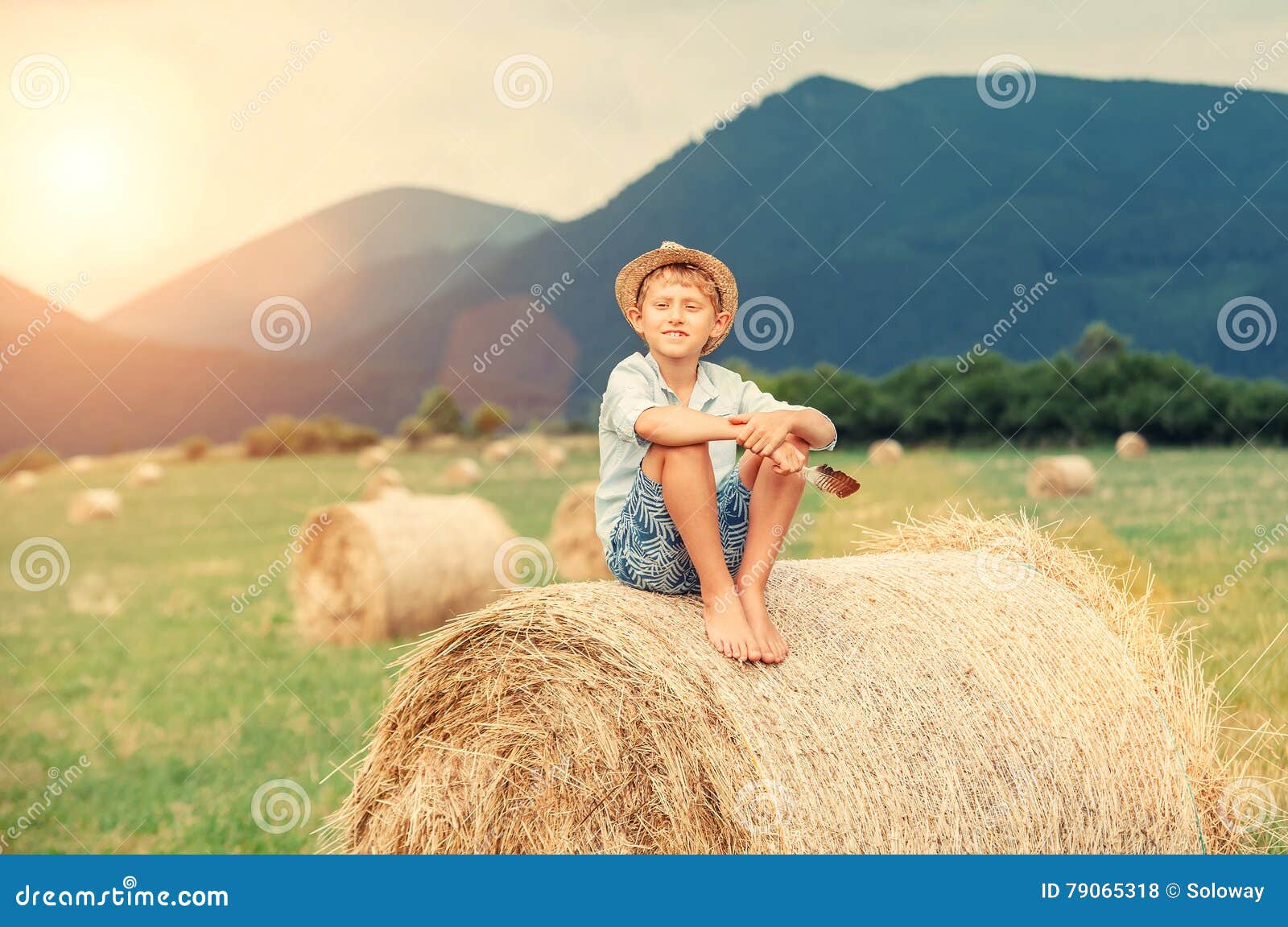 Boy Sits on the Haystack Top Stock Photo - Image of happy, countryside ...