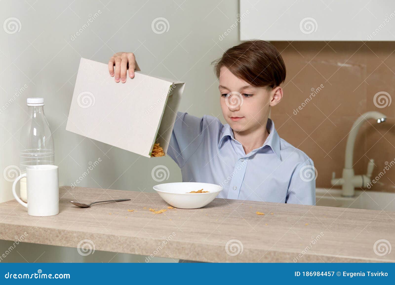 The Boy Sits in the Kitchen at the Table and Prepares a Breakfast of ...