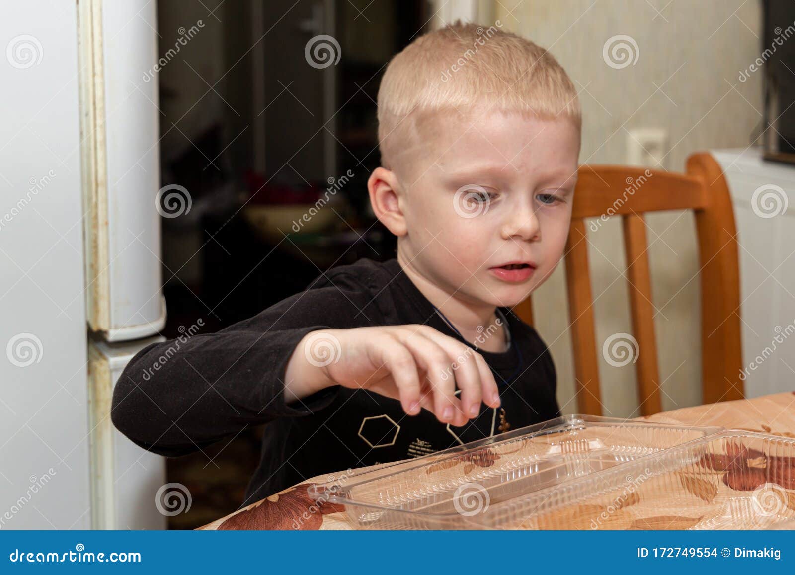 The Boy Sits at a Table with a Cake and Pulls His Hand To an Empty Box ...