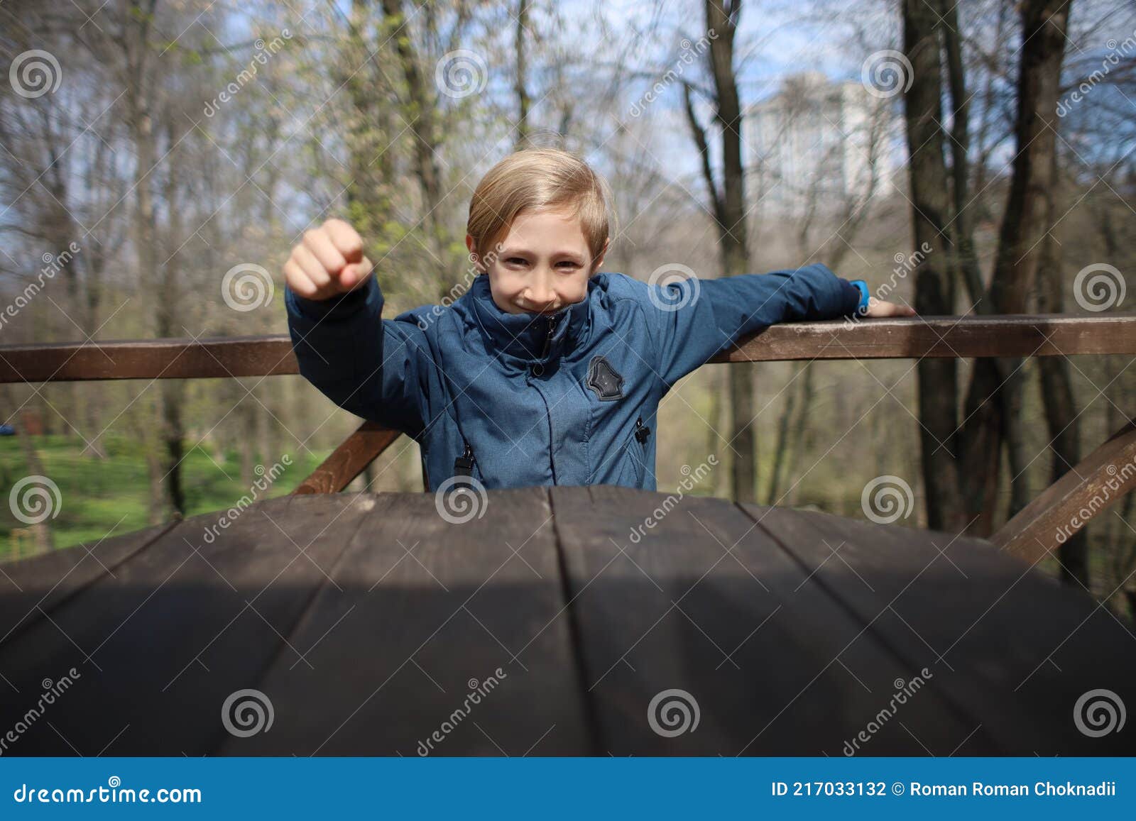 Boy Sits at a Wooden Table in a Cafe and Makes Various Gestures with ...