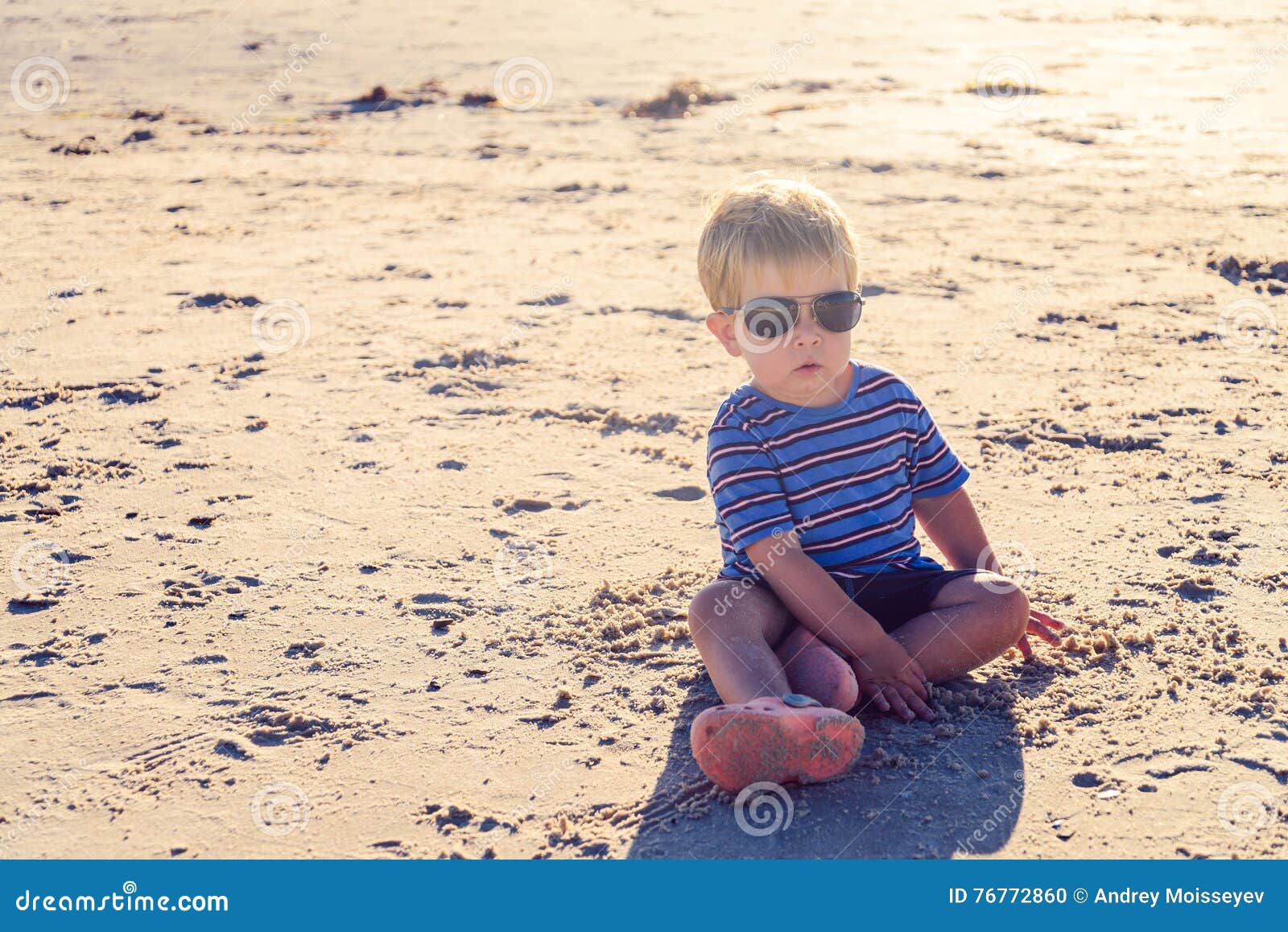 Boy sitting on the beach stock photo. Image of emotion - 76772860