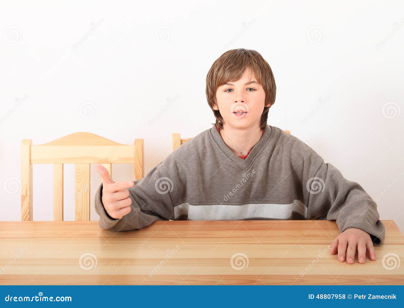 Boy Sitting Behind Wooden Table Stock Photo - Image of table ...