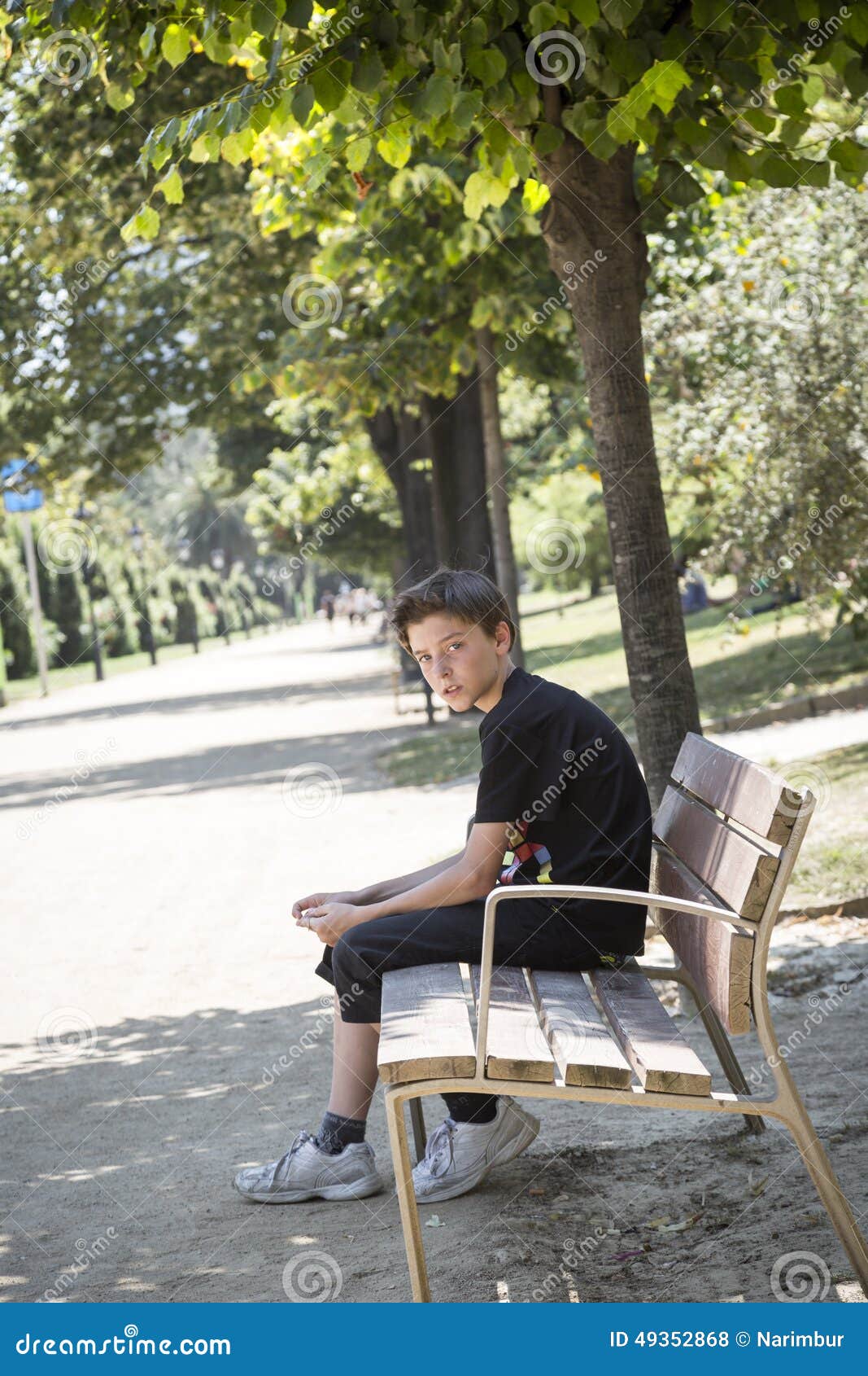 Boy Sitting on a Bench in a Park Stock Photo - Image of shadow, garden ...