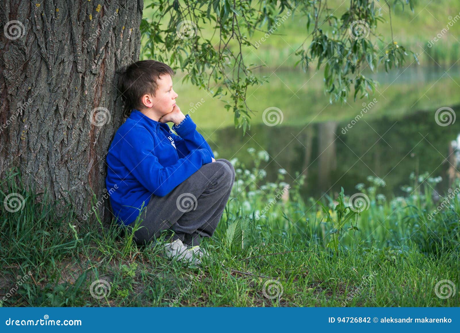The Boy is Sitting by the Big Tree. Stock Photo - Image of knees ...