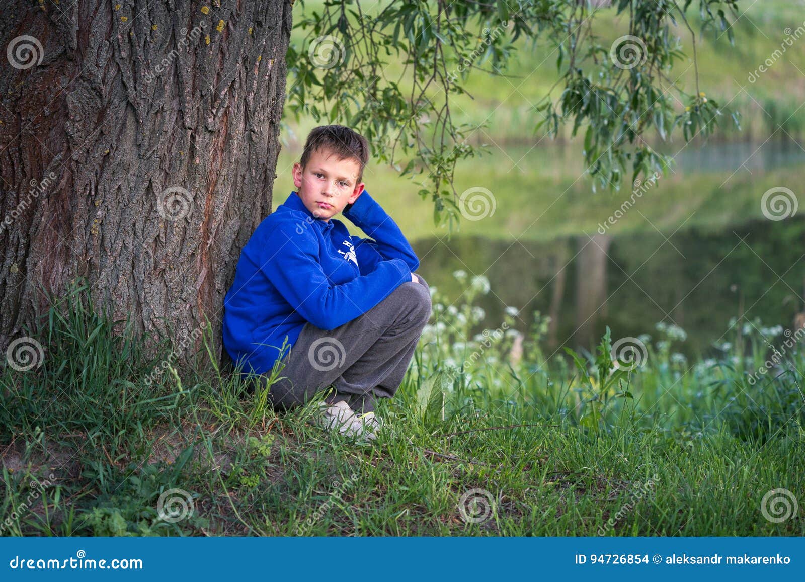 The Boy is Sitting by the Big Tree. Stock Photo - Image of male, nature ...