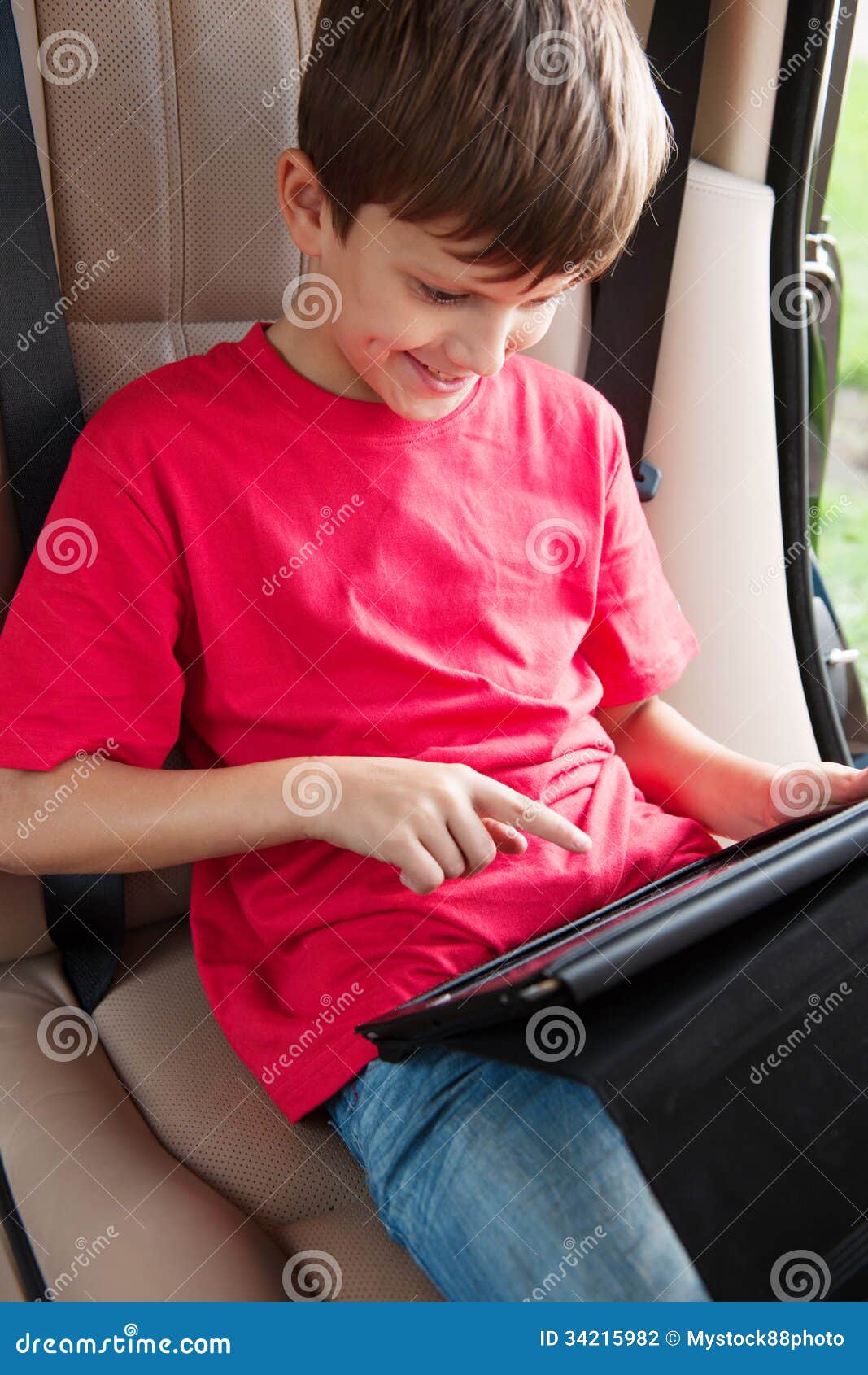 Boy is Sitting in a Car and Playing with Ipad. Stock Photo - Image of ...