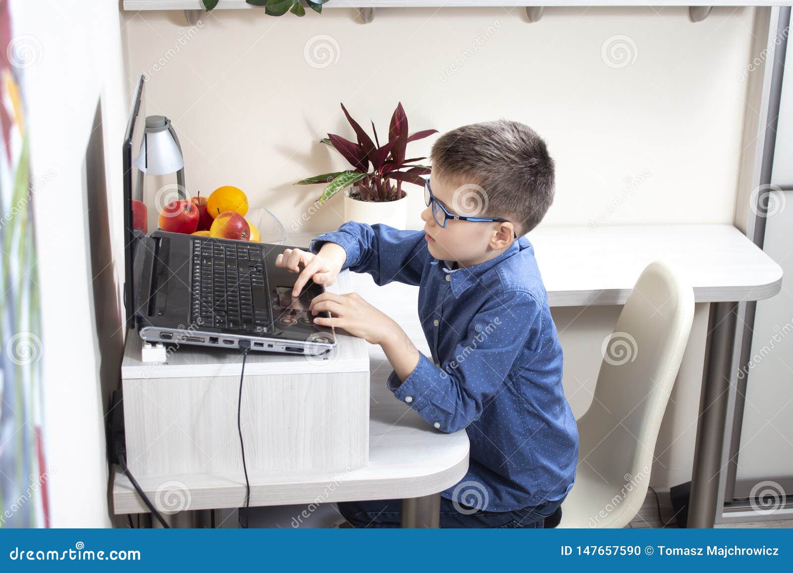 Boy is Sitting at a Desk in Front of a Laptop. Both Hands on the ...