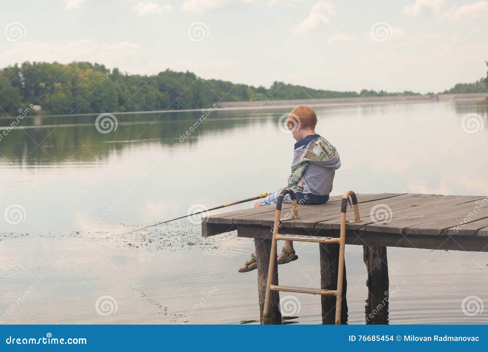 Boy Sitting and Fishing from a Dock Stock Photo - Image of holding ...