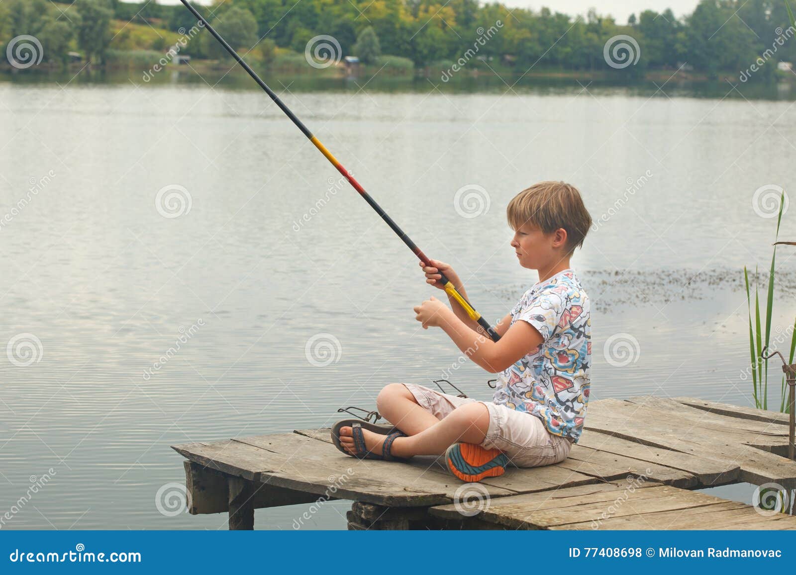 Boy Sitting and Fishing from a Dock Stock Photo - Image of river, fish ...