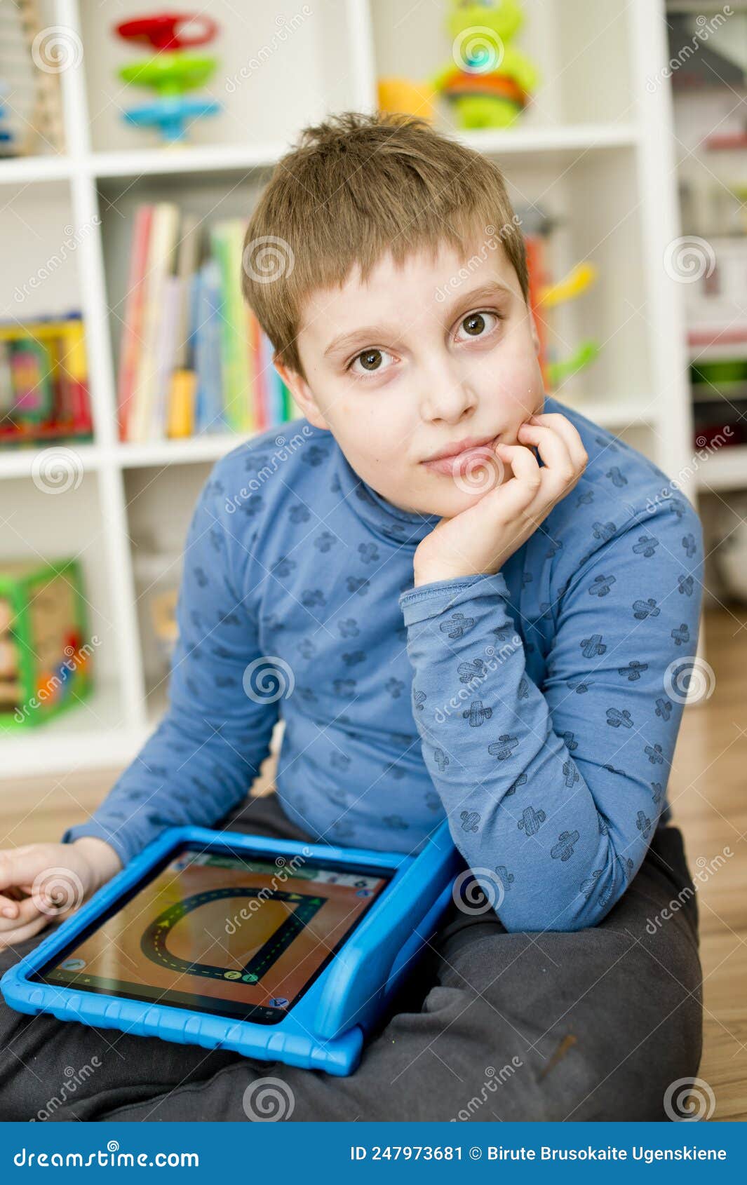 Boy Sitting on the Floor and Gaming with Blue IPad. Stock Image - Image ...