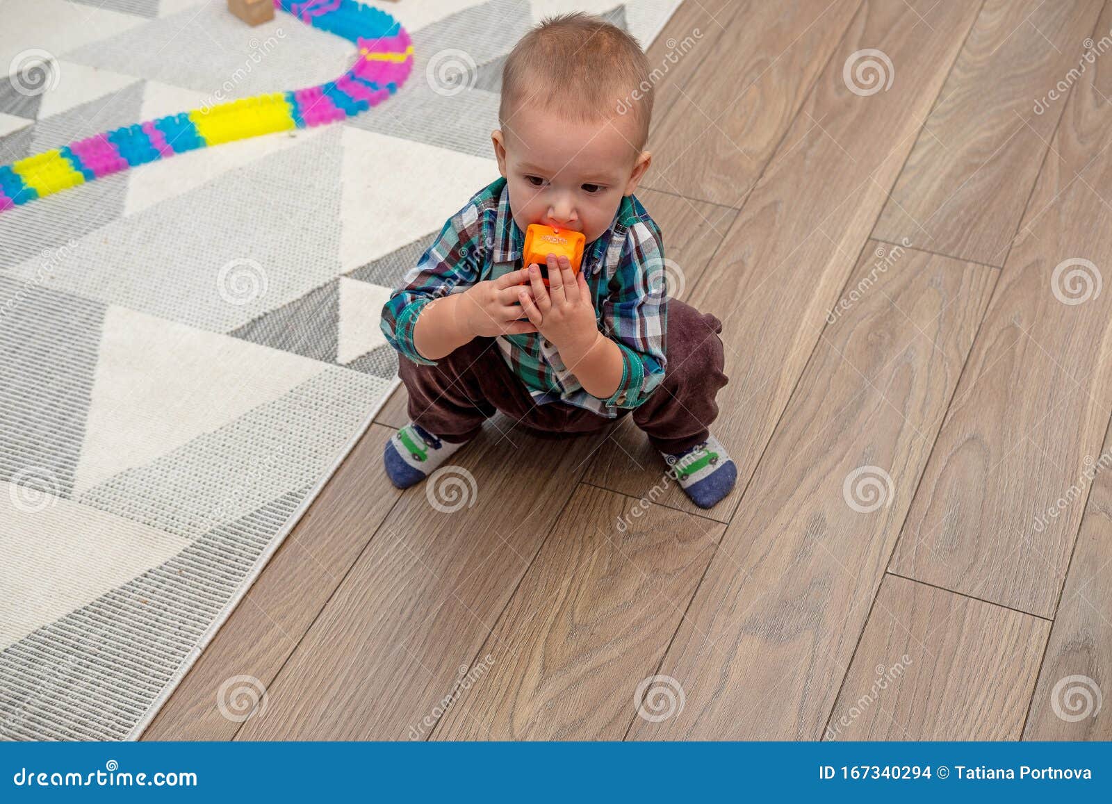 Boy Sitting on the Floor in the Playroom Playing with Toys Stock Photo ...