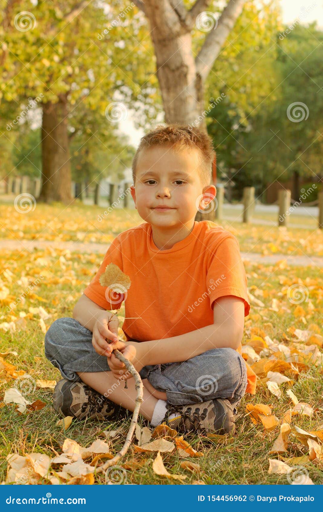 Boy Sitting on the Grass in the Park Stock Photo - Image of yellow ...