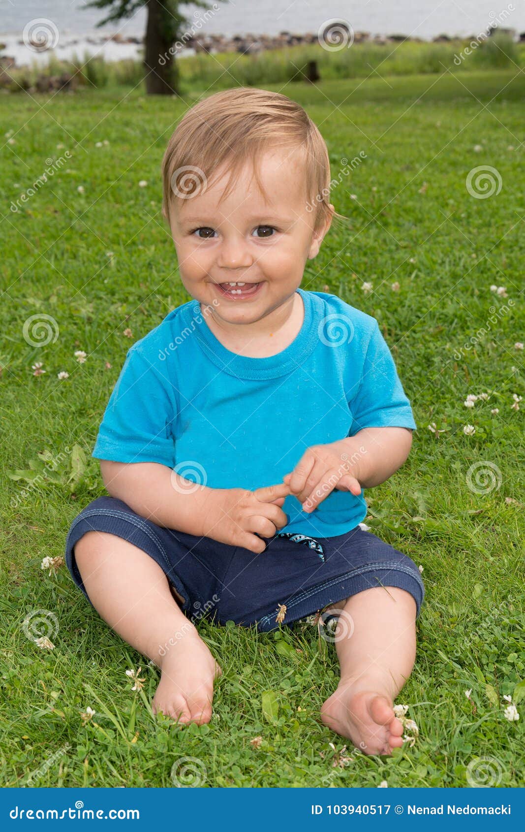 The Boy is Sitting on the Grass and Playing Stock Image - Image of cute ...