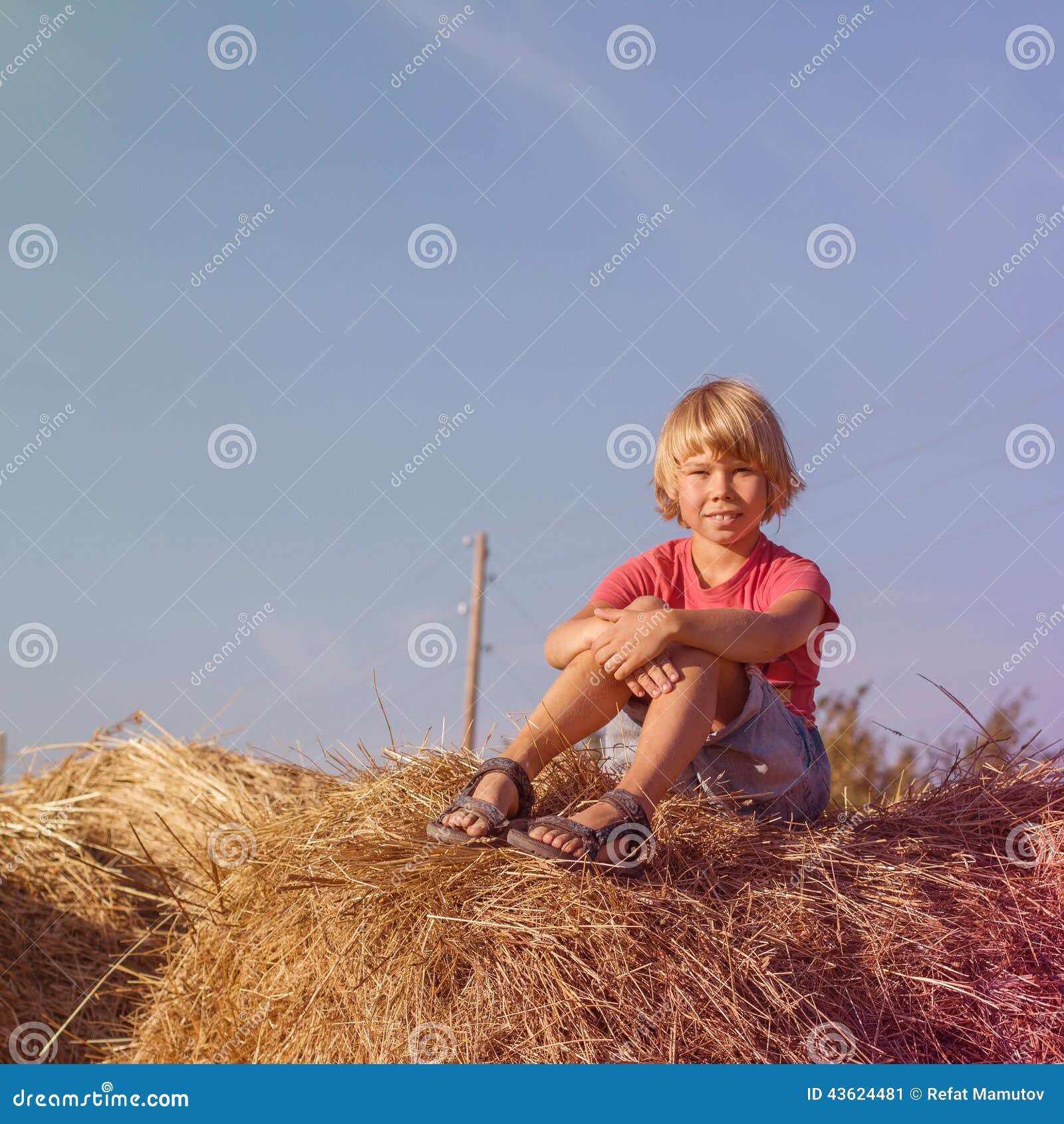 Boy sitting on a haystack stock image. Image of outdoor - 43624481