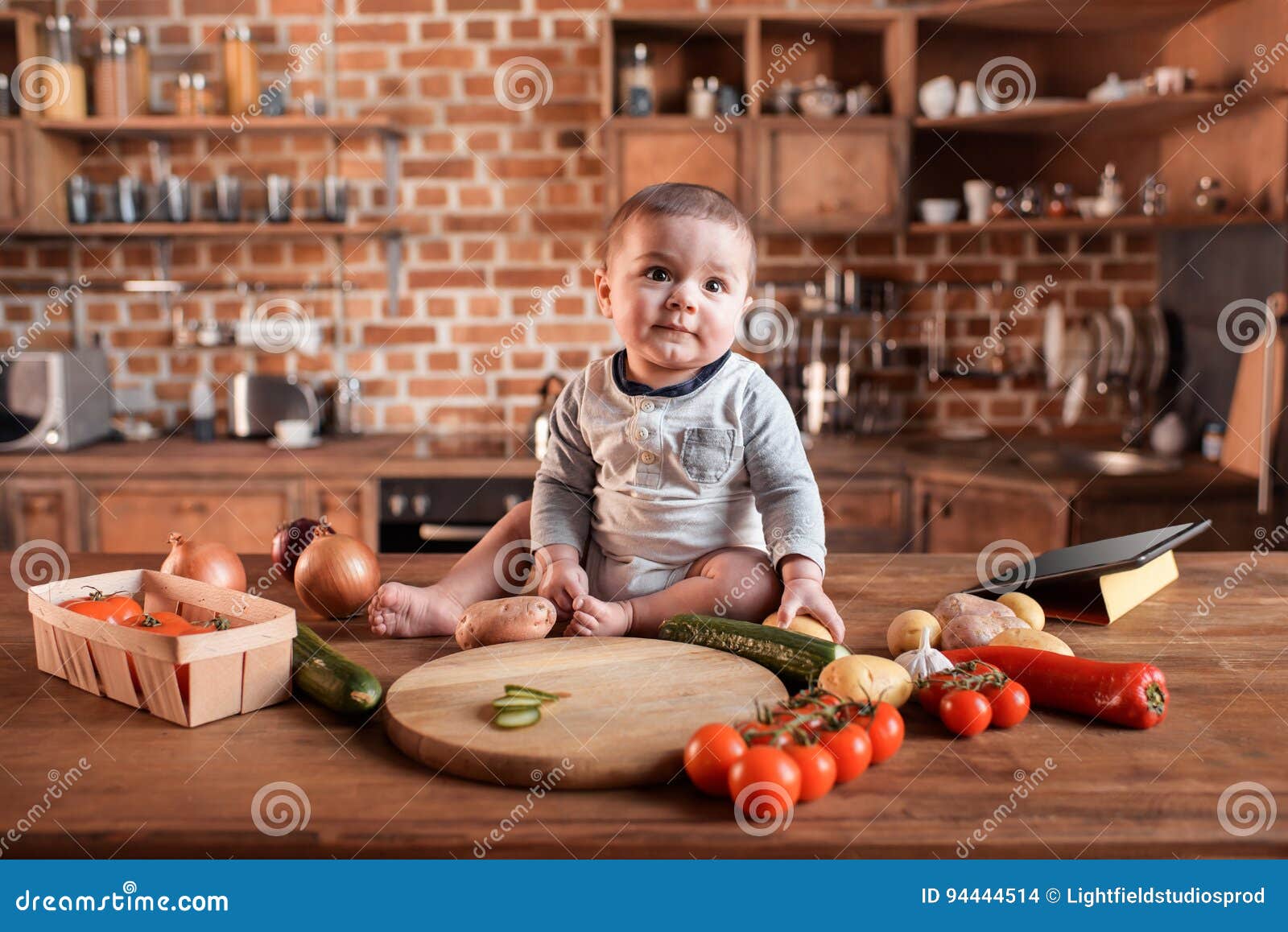 Boy Sitting on Kitchen Table Around of Raw Vegetables before Cooking a ...