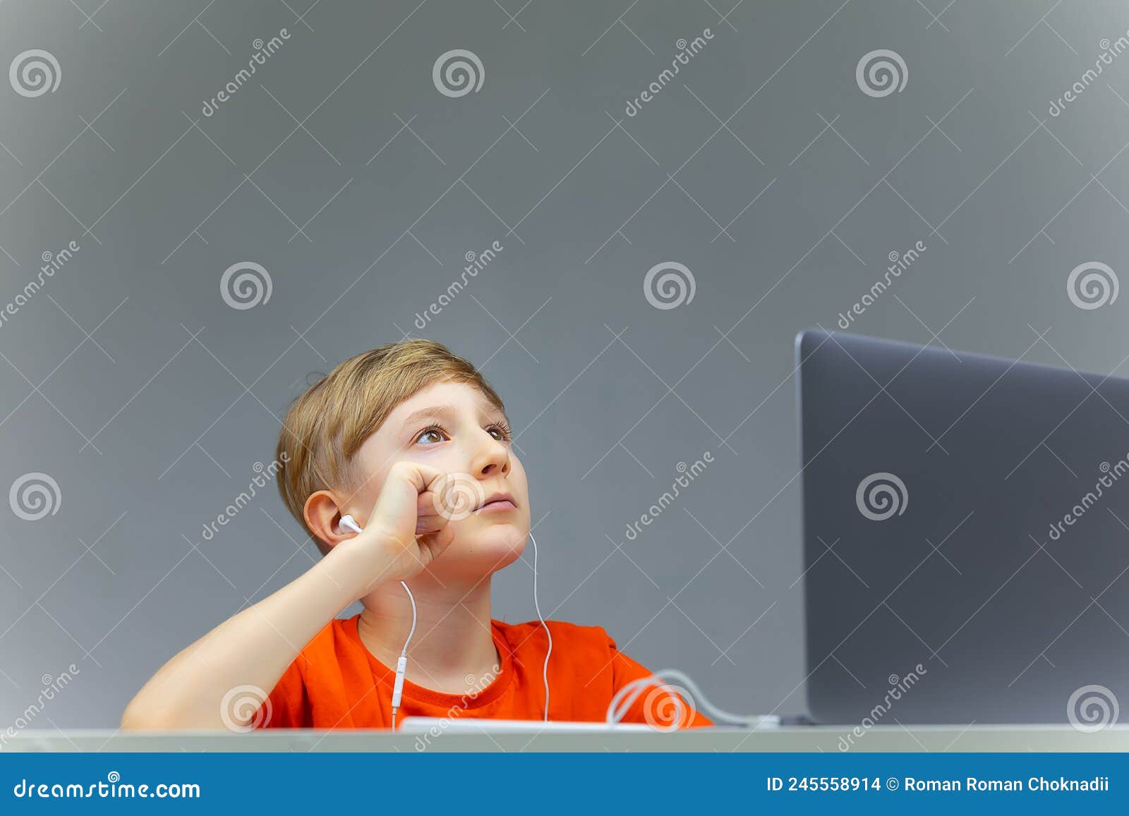 A Boy Sitting at a Laptop Thinking and Looking Up Stock Photo - Image ...