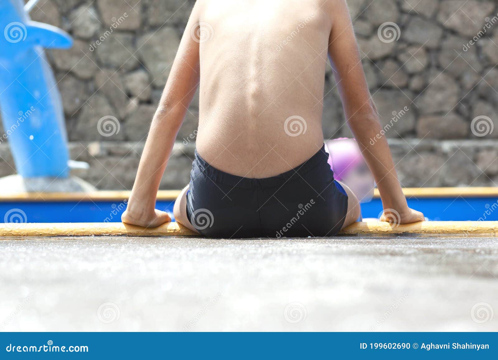 Boy sitting by the pool stock photo. Image of vacation - 199602690