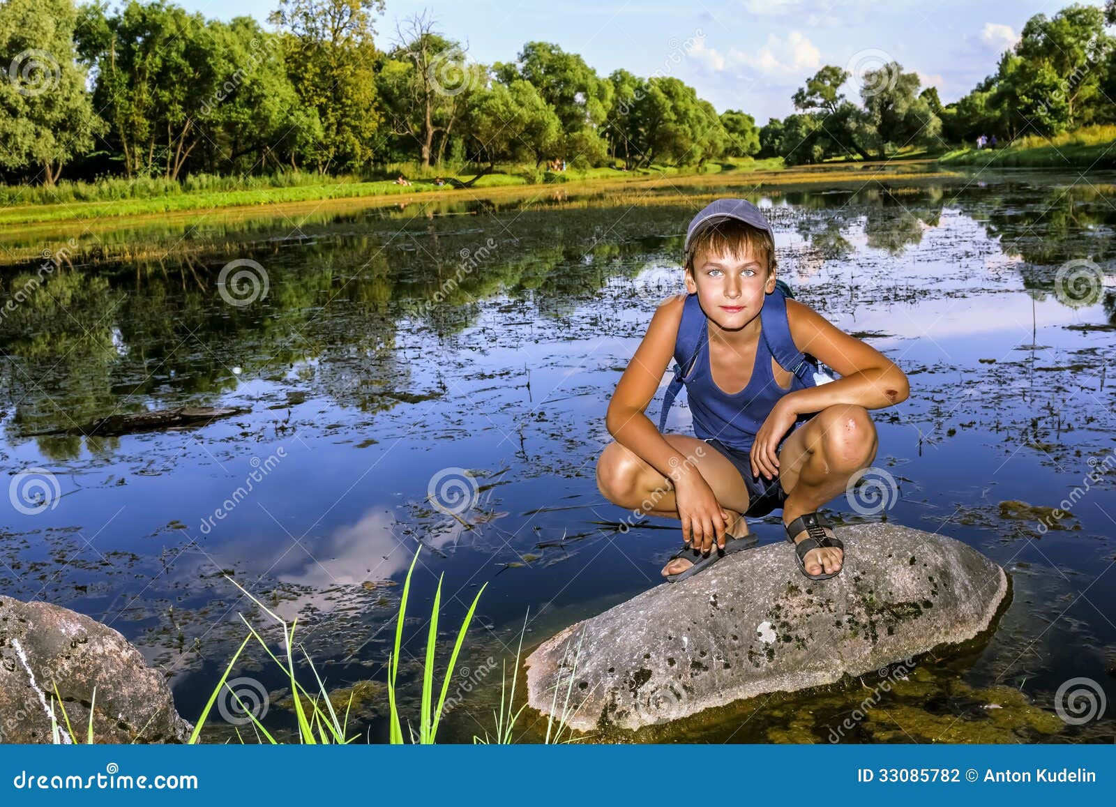 The Boy is Sitting on a Rock by the Lake Stock Photo - Image of ...