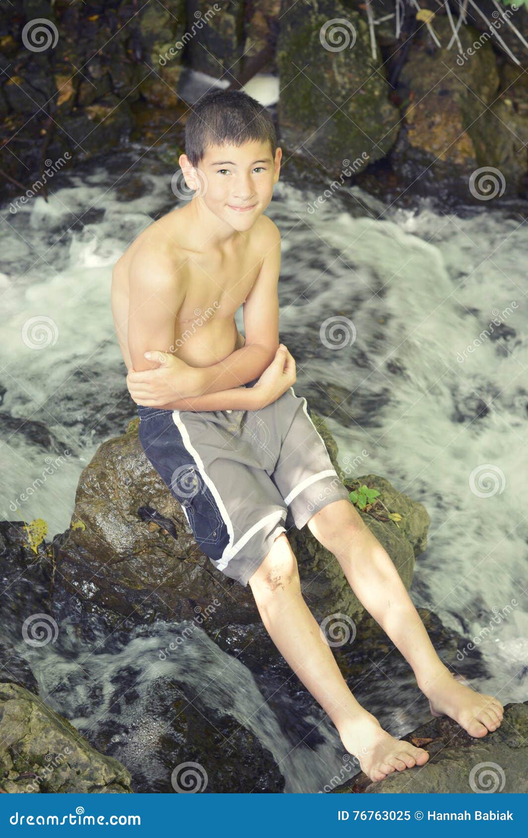 Boy Sitting on Rock by River Stock Image - Image of trunks, flowing ...