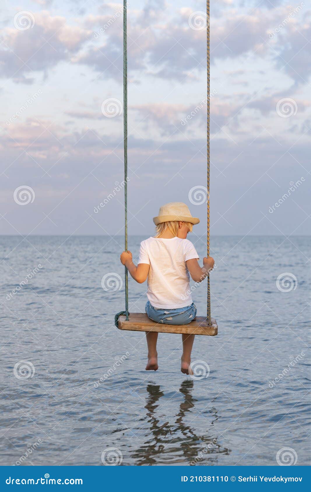 Boy Sitting on Rope Swing Over the Water. Swing on Beach Stock Photo ...
