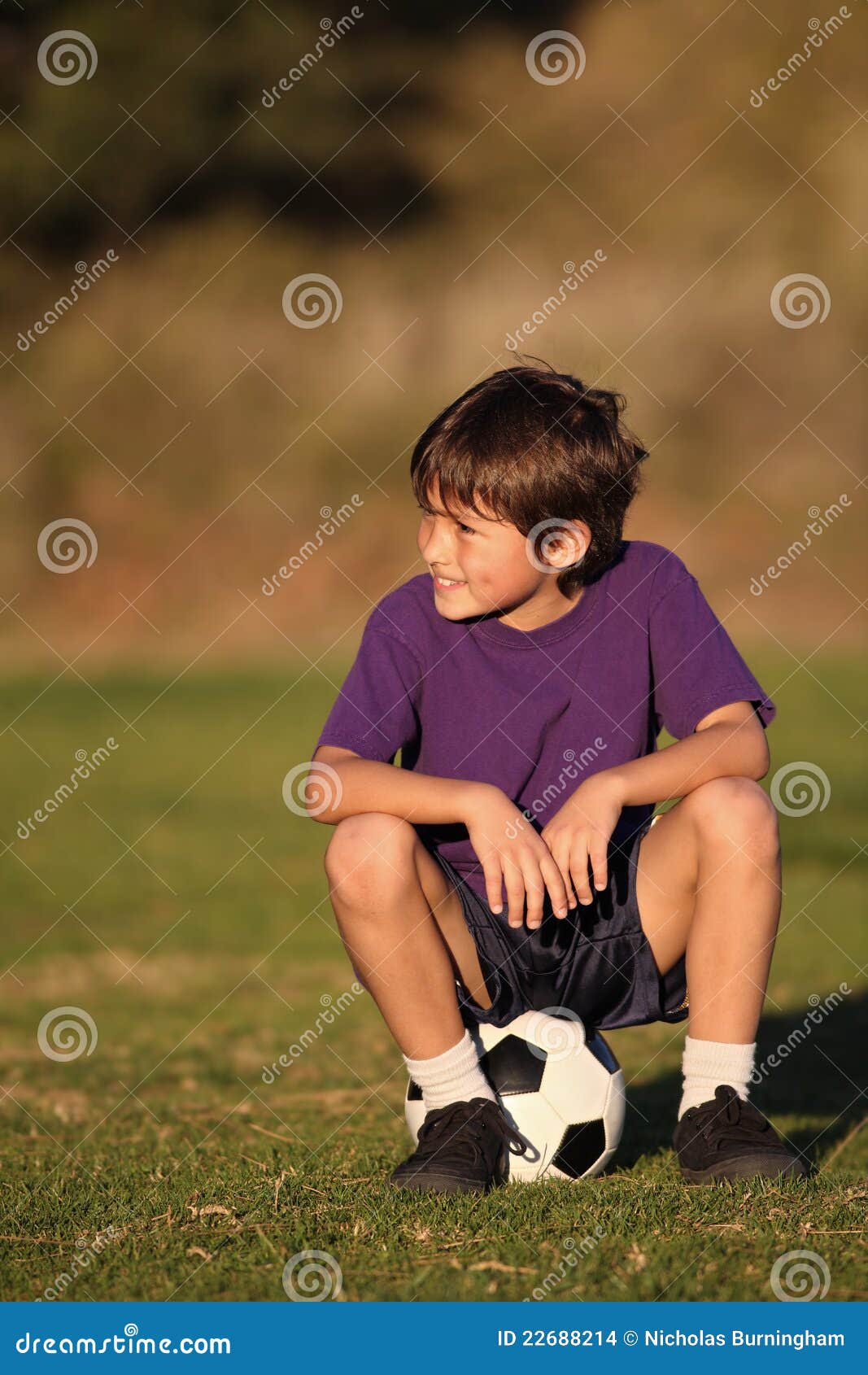 Boy sitting on soccer ball stock photo. Image of game - 22688214